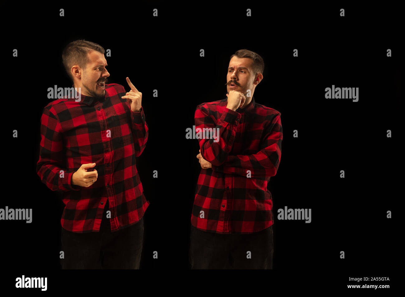 Young handsome man arguing with himself on black studio background ...