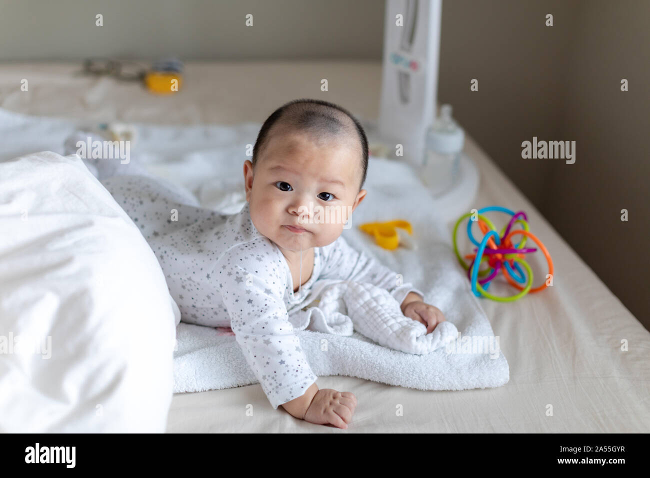 Adorable baby boy doing tummy time on bed. Family morning at home Stock ...
