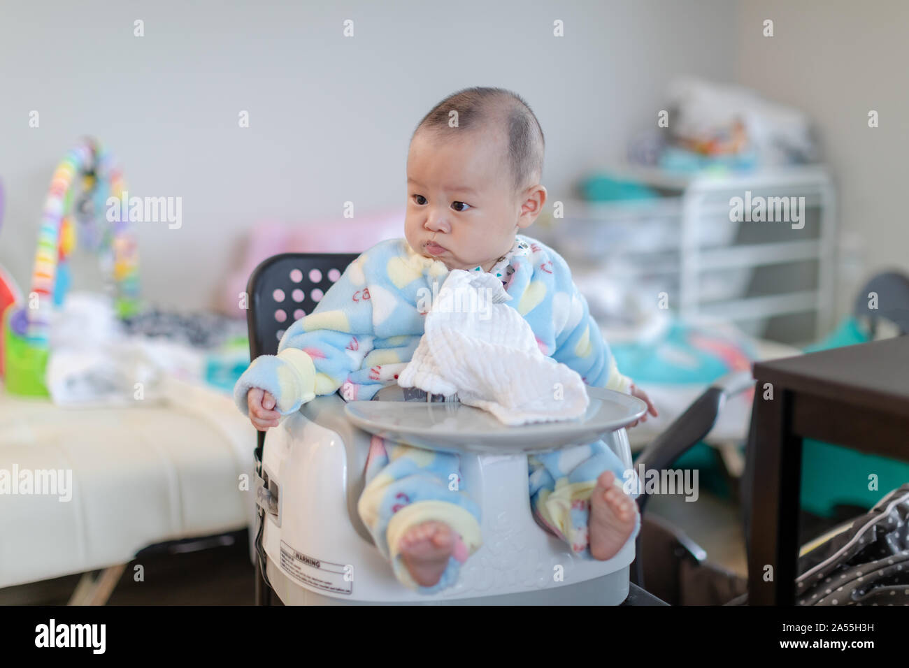 Little drooling baby boy sitting on chair at home. Winter season Stock ...