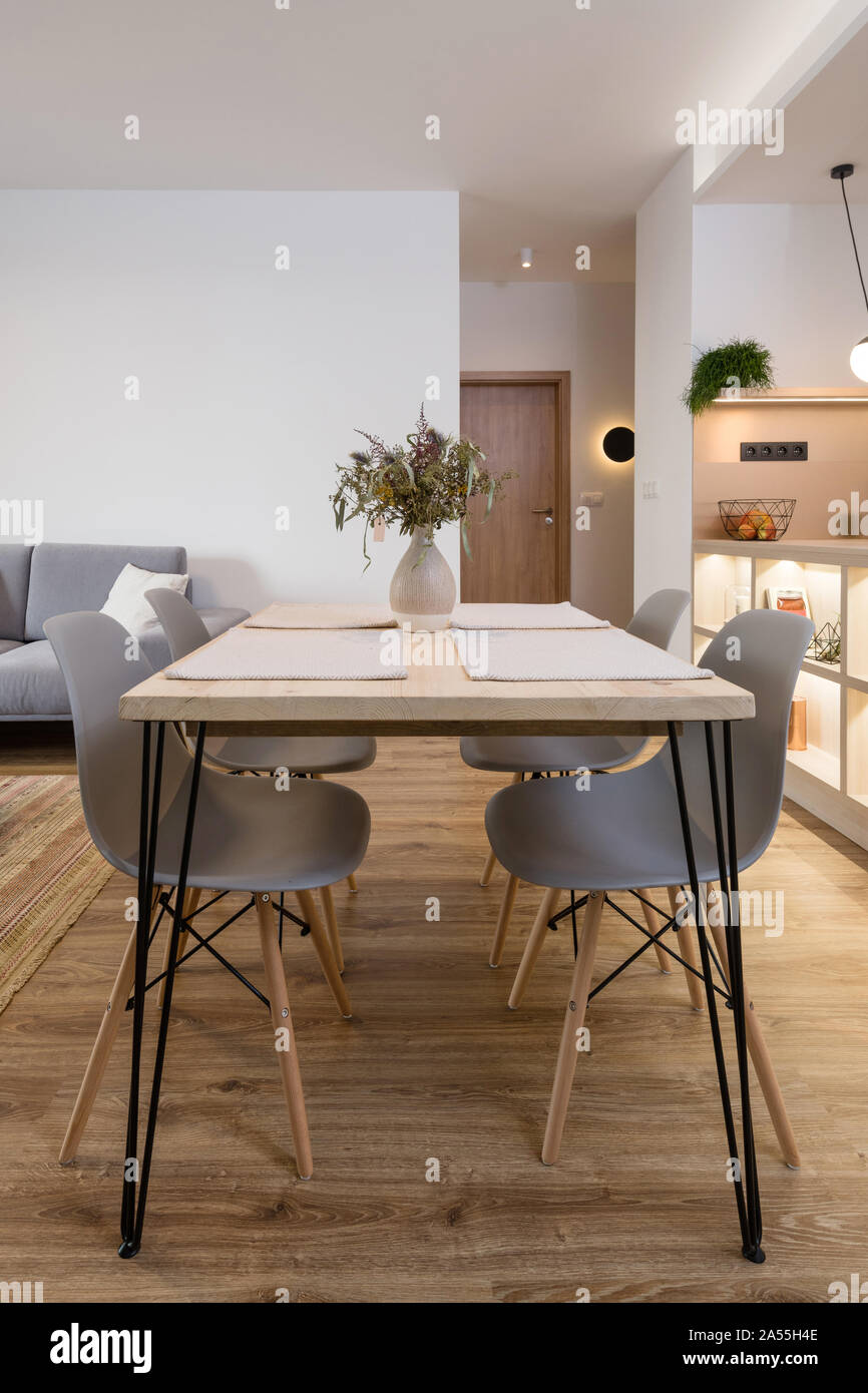 Dining table between kitchen and living room in contemporary apartment ...
