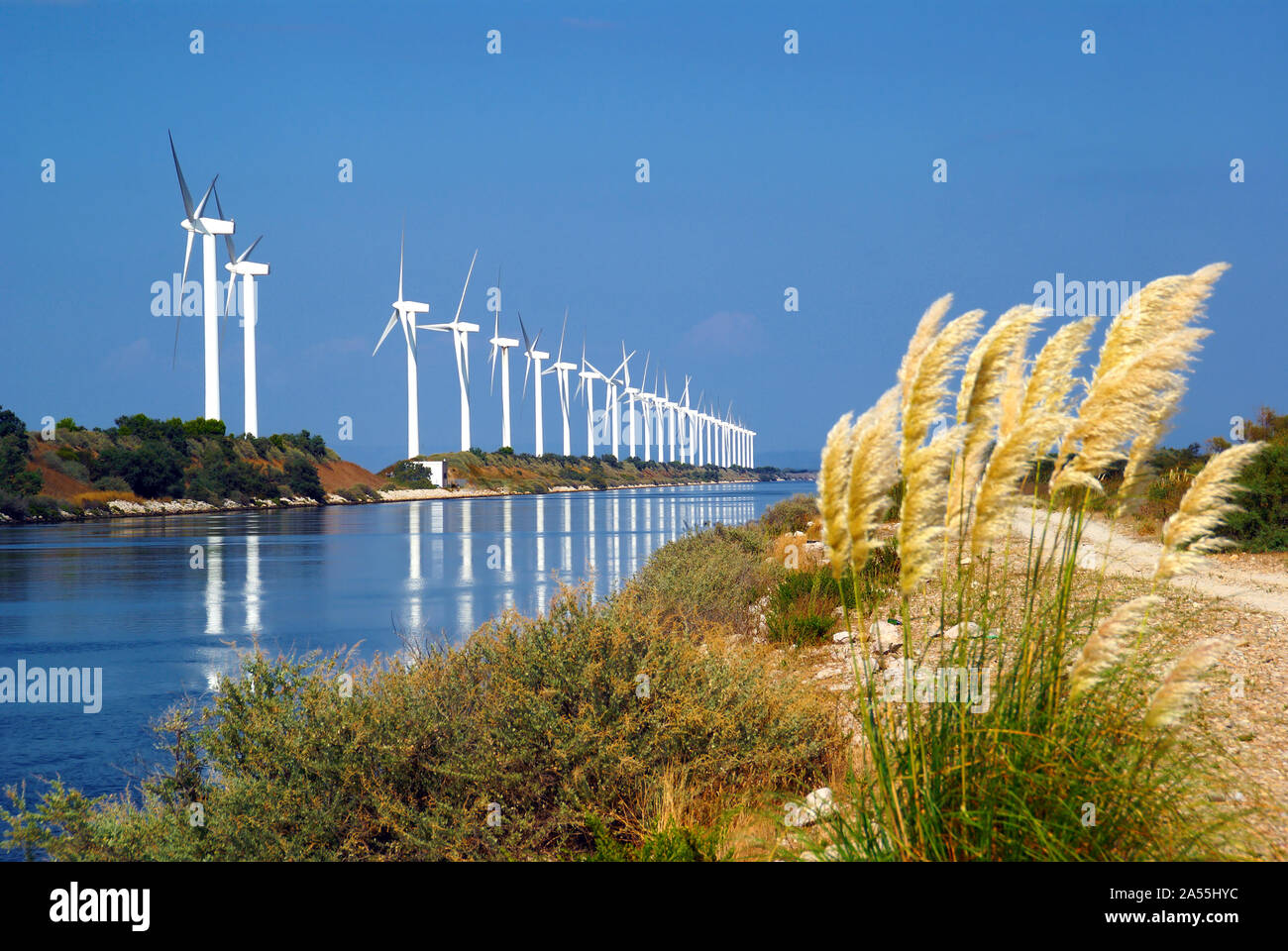 Alignment of wind turbines along a canal Stock Photo - Alamy