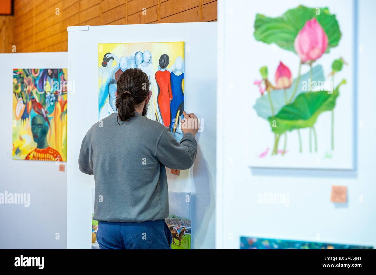 Straubing, Germany. 18th Oct, 2019. A prisoner hangs a picture on a ...