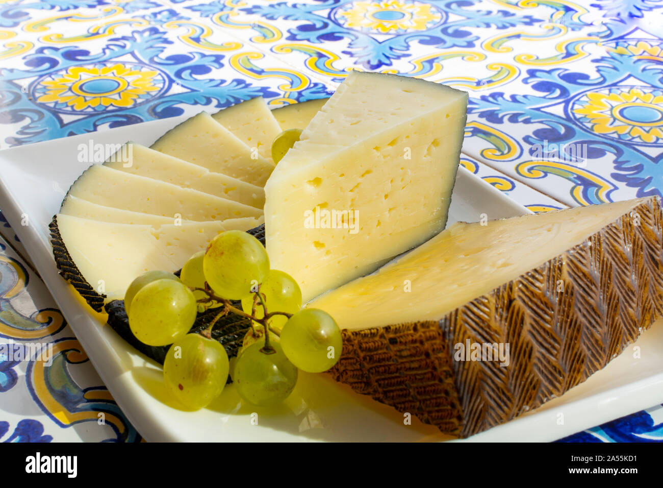 Spanish sheep cheese served with white grapes on andalusian style table ...
