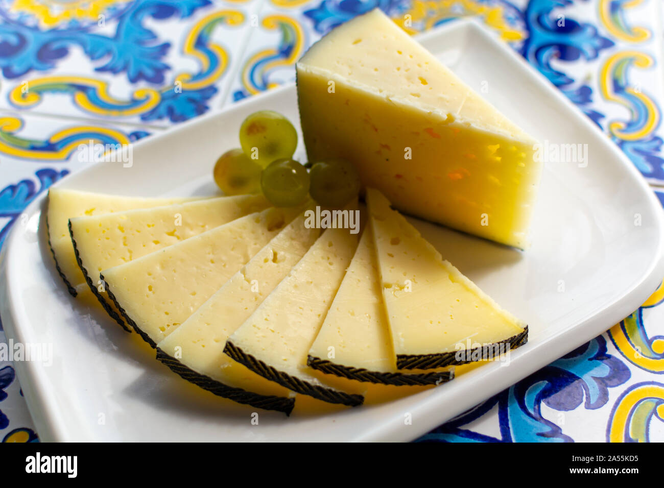 Spanish sheep cheese served with white grapes on andalusian style table ...