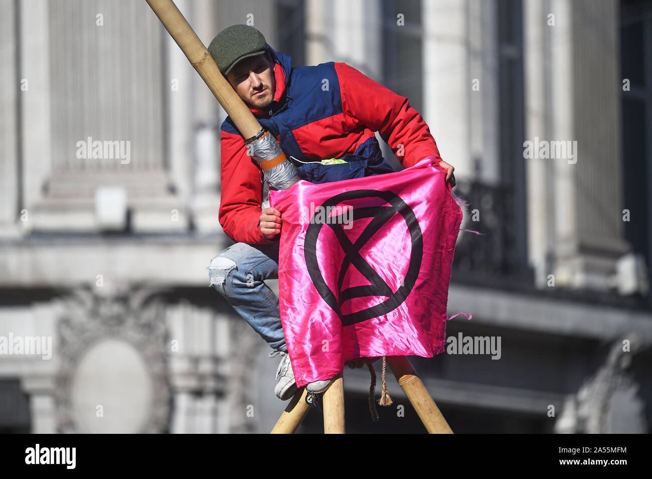 A protester sits on top of a bamboo structure built to block the road ...