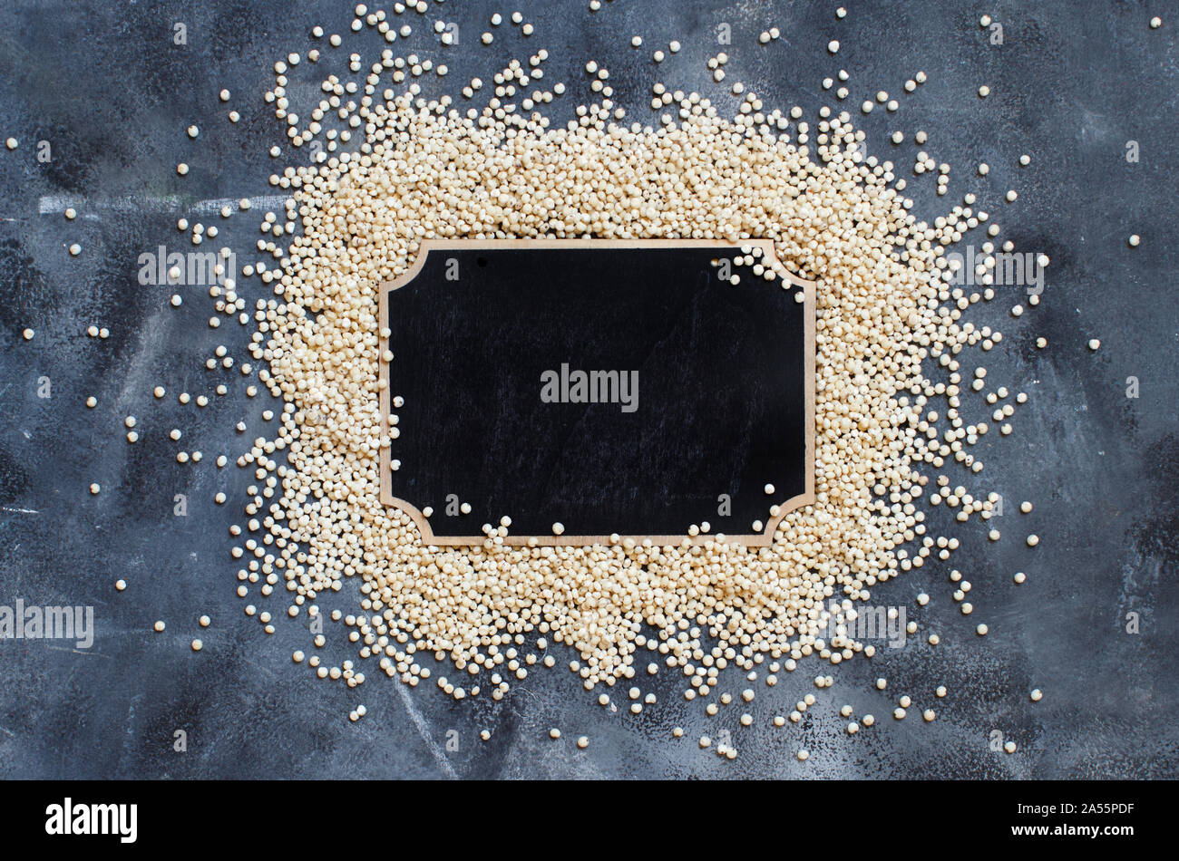 Raw White Sorghum grain with a small chalkboard top view on a gray ...