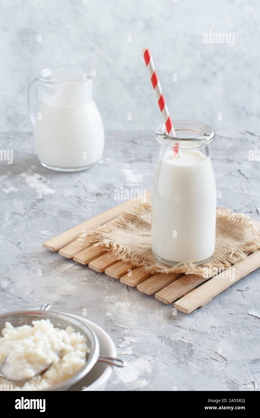 Fermented drink kefir in small bottles and kefir grains on a white ...