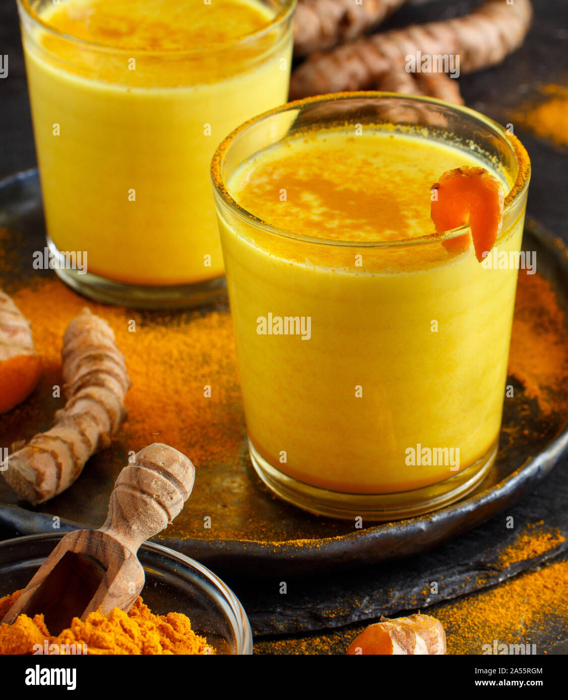 Golden milk with turmeric powder in a glass close up Stock Photo - Alamy