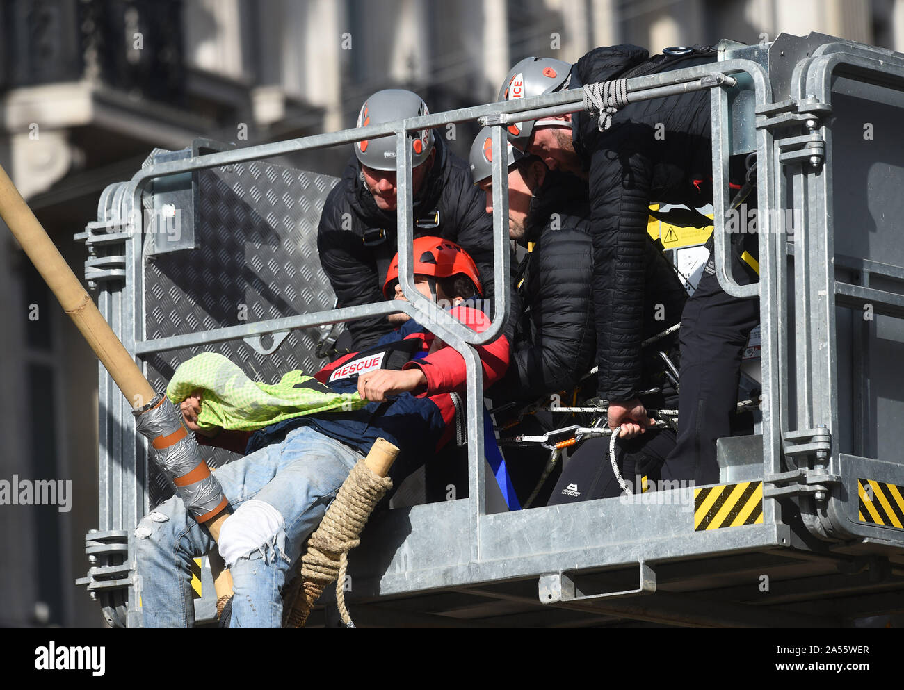 Police attempt to remove a protester that is sat on top of a bamboo ...