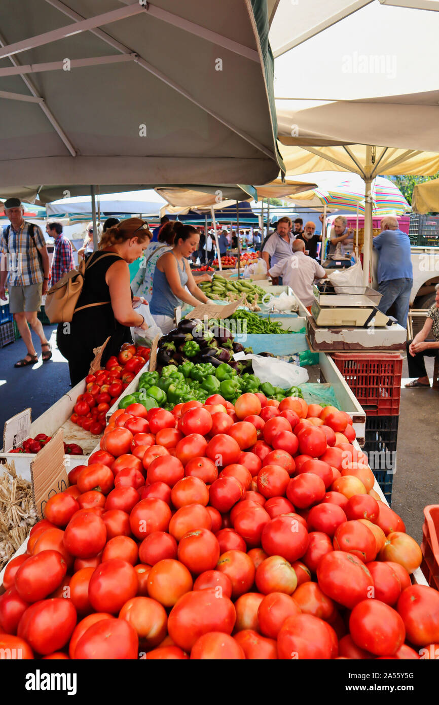 Fresh vegetables at a market stall with people Stock Photo - Alamy