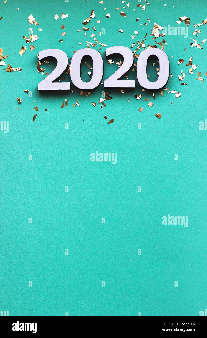 2020 white wooden letters and golden sparkles on mint backdrop. Festive ...