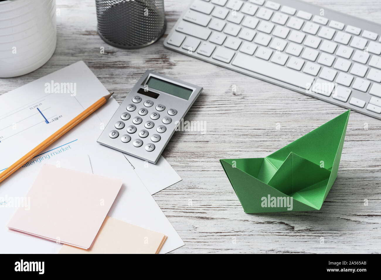 Modern office workspace with green paper ship. Eco-friendly business ...