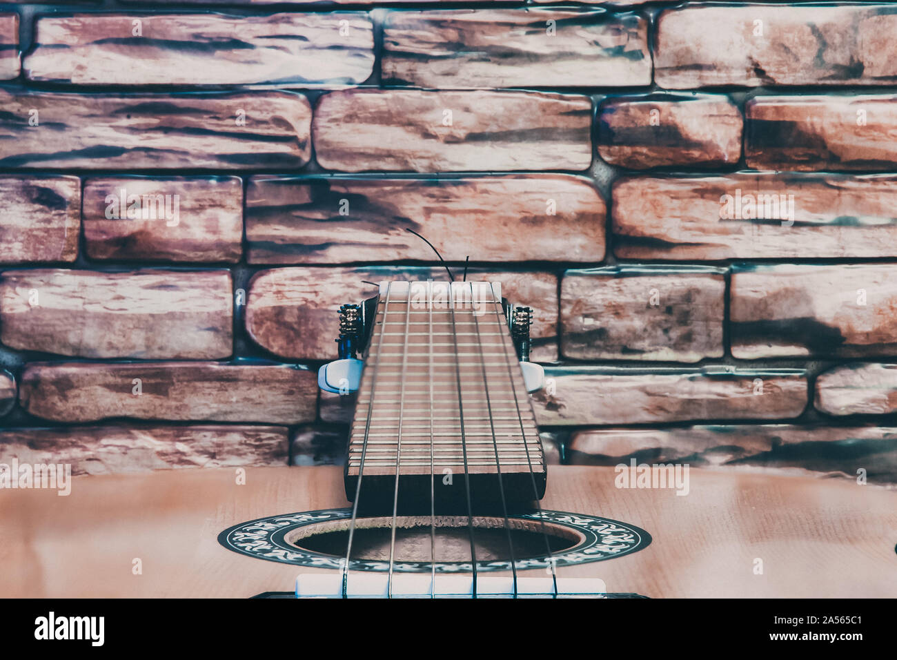 Acoustic guitar on red brick wall background Stock Photo - Alamy