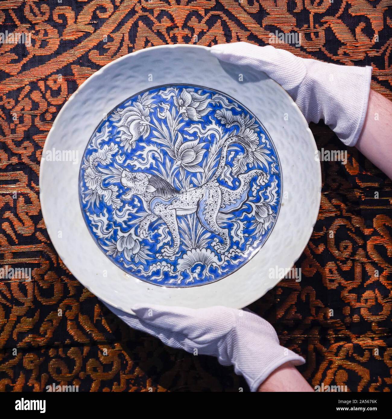 London, UK. 18 October 2019. A technician presents a "Safavid blue and ...
