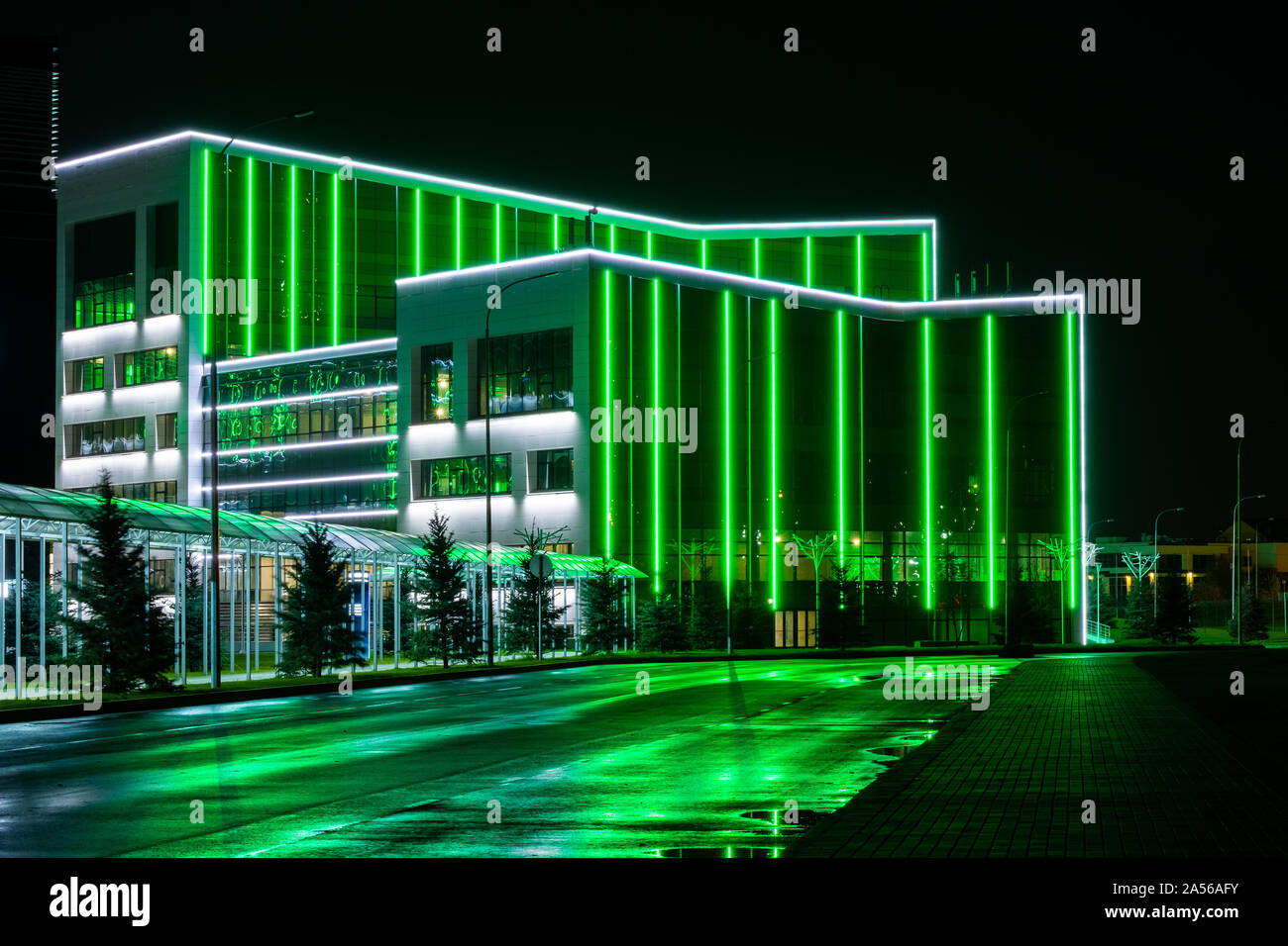 Modern tech building framed by a line of green neon lights. A ...