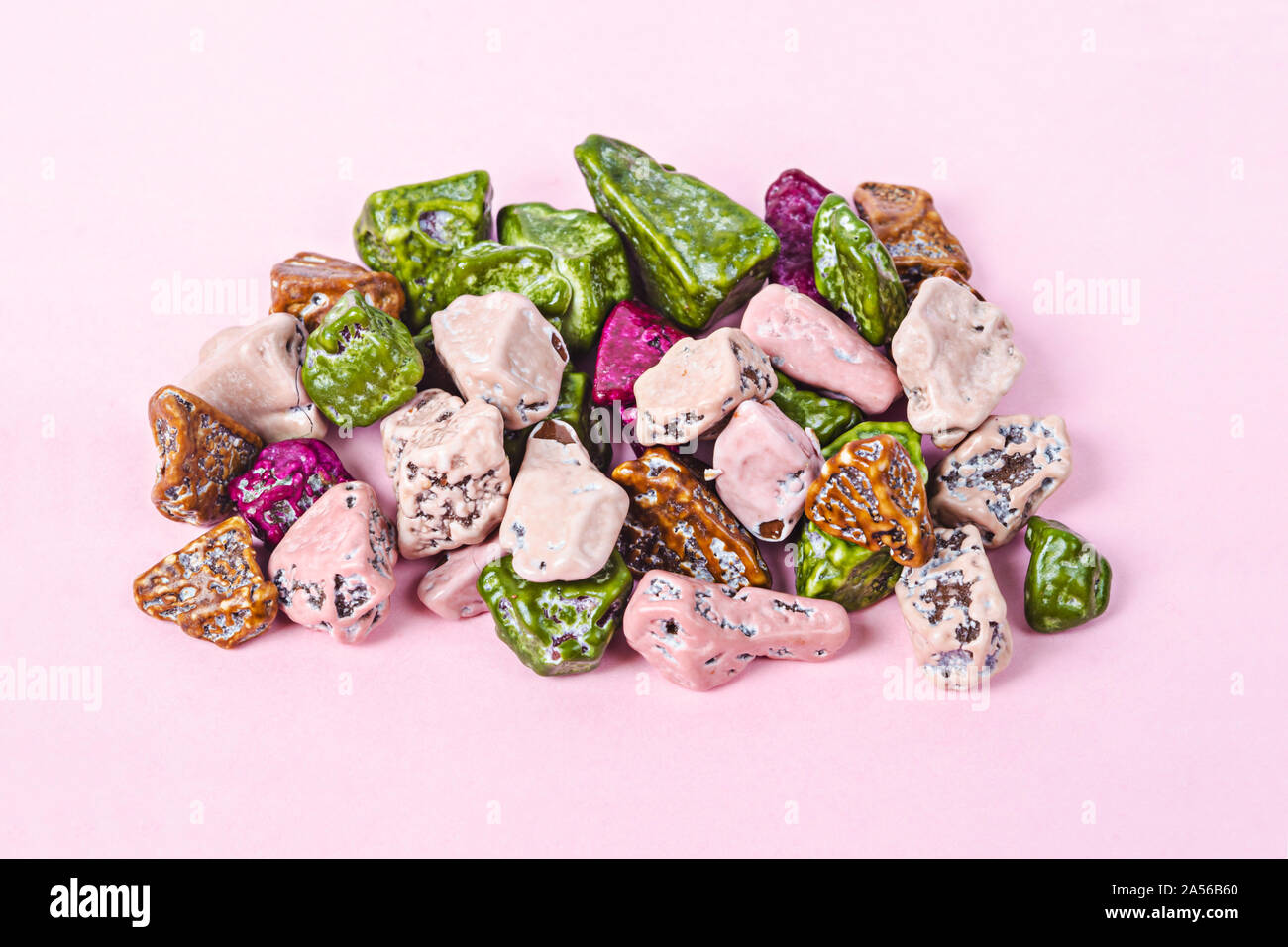 Heap of chocolate candy stones on pastel pink background Stock Photo ...