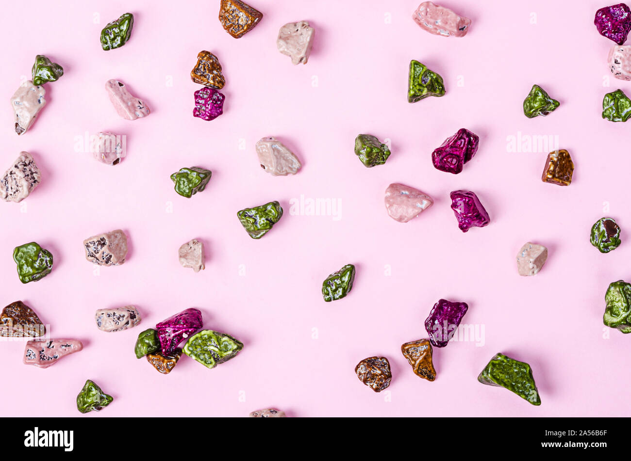 Pink background of chocolate candy stones Stock Photo - Alamy