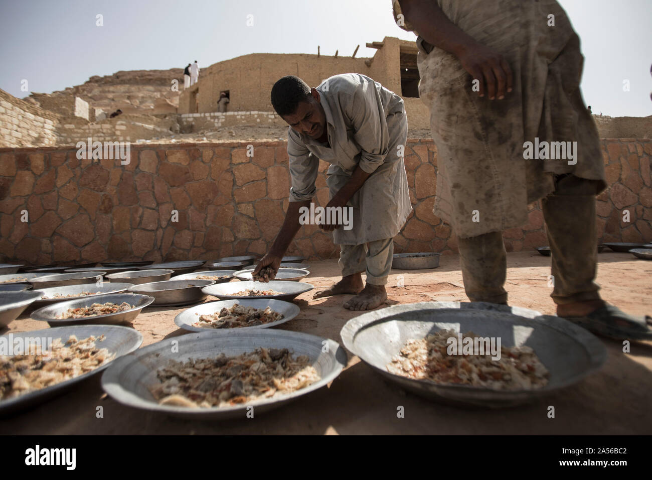 16 October 2019, Egypt, Siwa: Cooks prepare and sort food plates to be ...