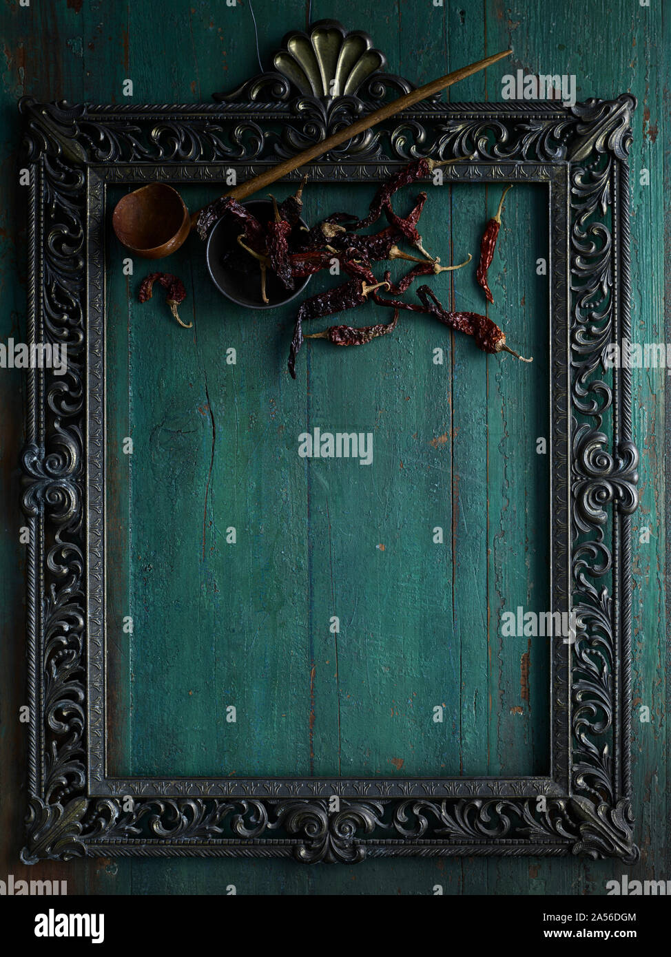 Rustic low key still life with dried chillies and bowl in picture frame ...