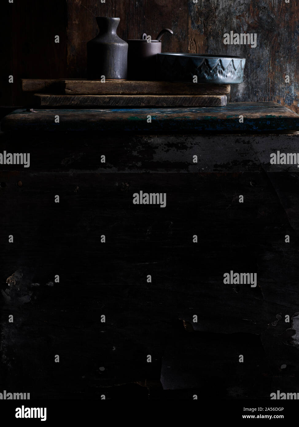 Rustic low key still life with ceramic bowl, jar and pot on cutting ...