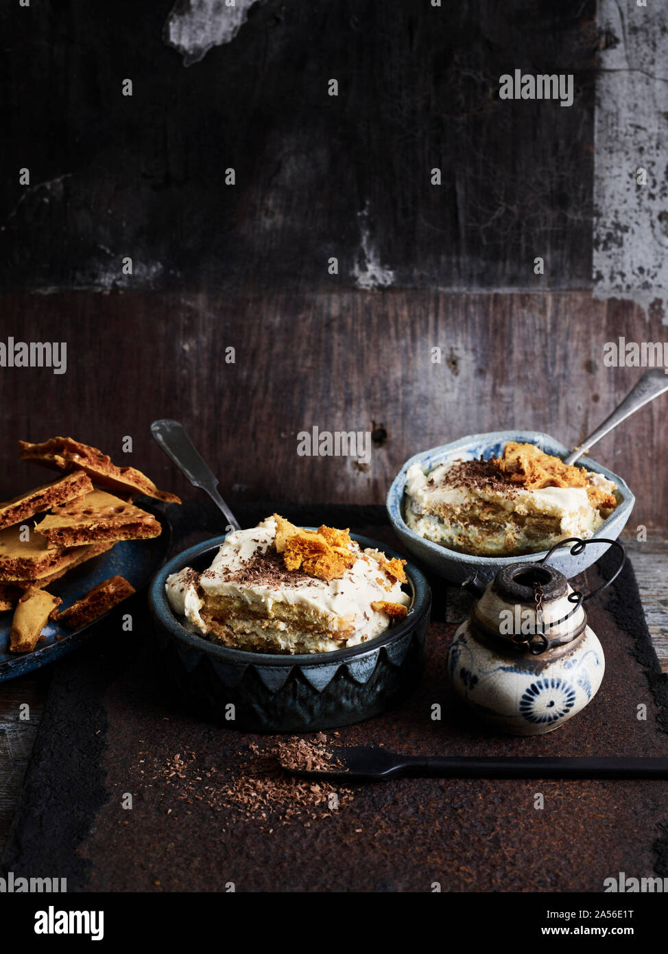 Rustic low key still life with bowls of tiramisu, chocolate and ...