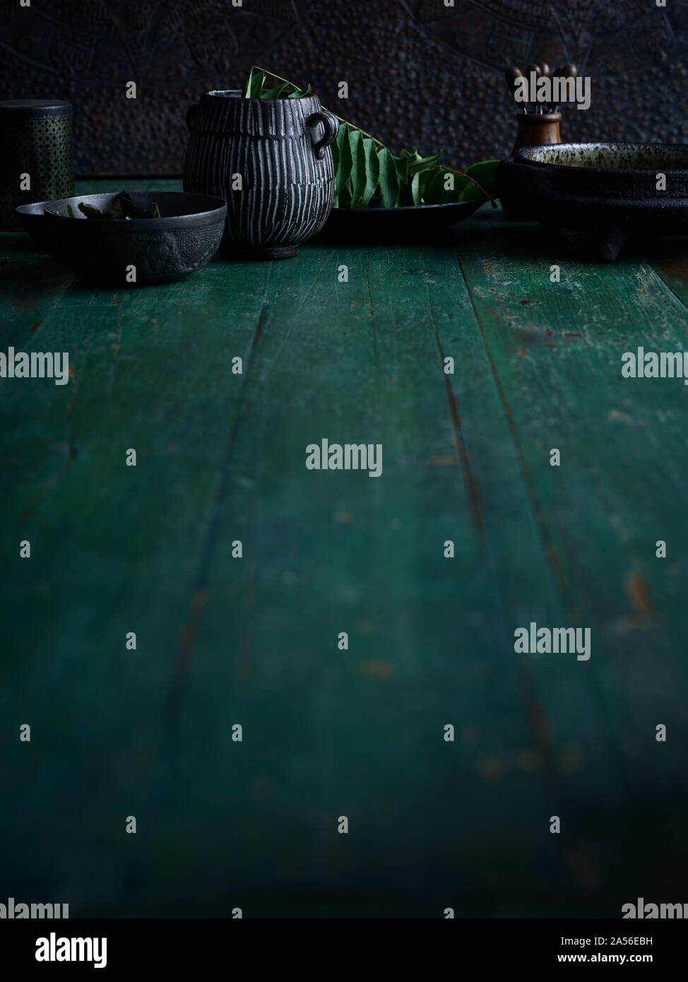 Rustic low key still life with bowls and jug on green wooden table ...