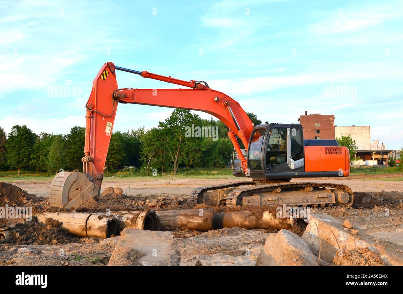 Excavator at a construction site during earthworks and laying of ...