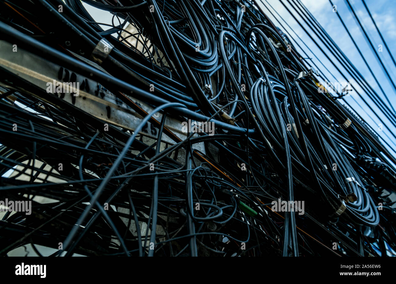 Tangled electrical wires on urban electric pole. Disorganized and messy ...