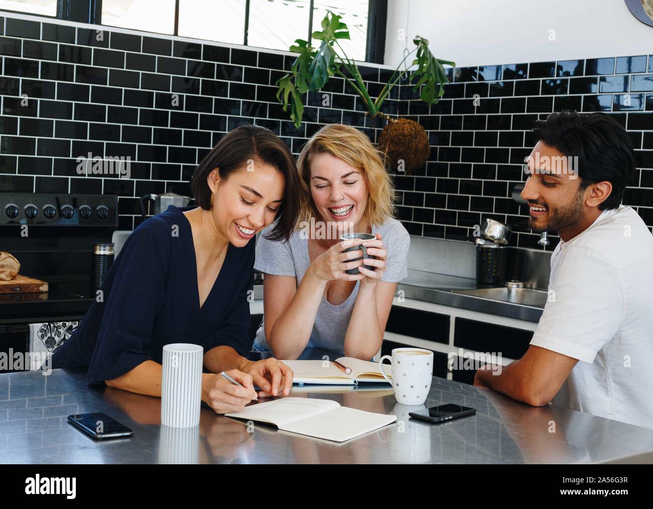 Colleagues talking and working at coffee break in pantry Stock Photo ...