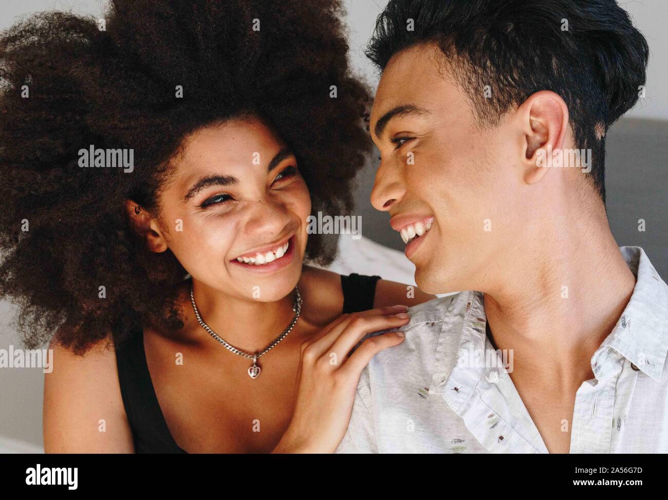 Happy young woman and boyfriend looking at each other in bedroom Stock ...