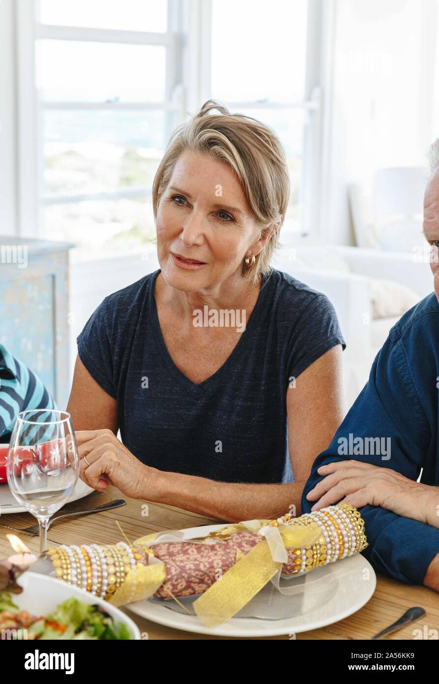 Woman listening attentively at dining table in home party Stock Photo ...