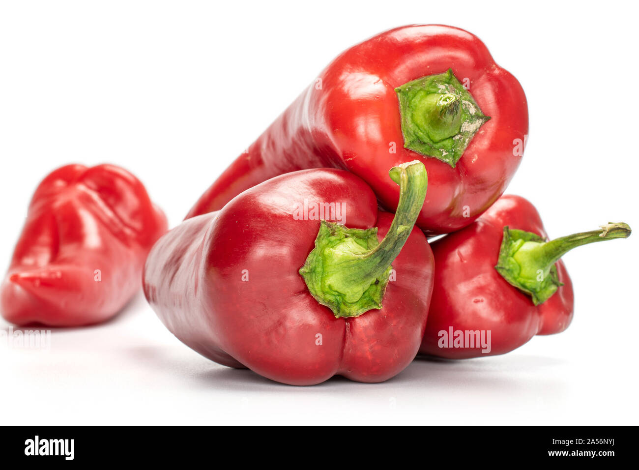 Group of four whole sweet red bell pepper isolated on white background ...