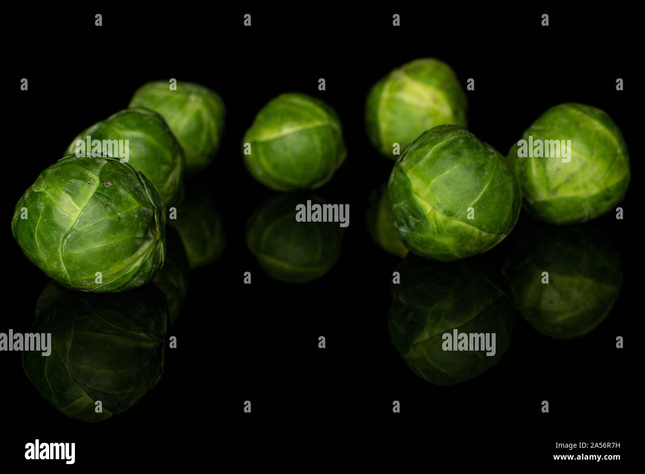 Group of seven whole fresh green brussels sprout isolated on black ...