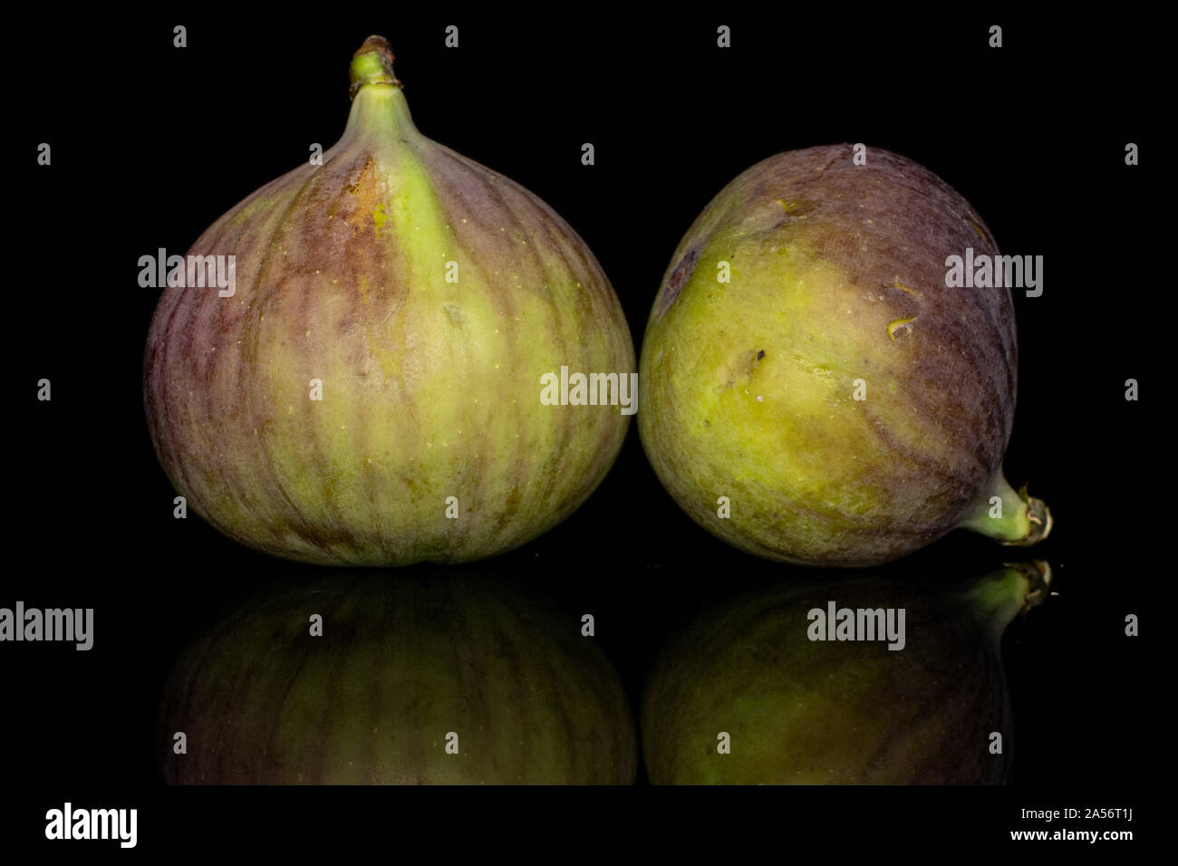 Group of two whole sweet purple fig isolated on black glass Stock Photo ...