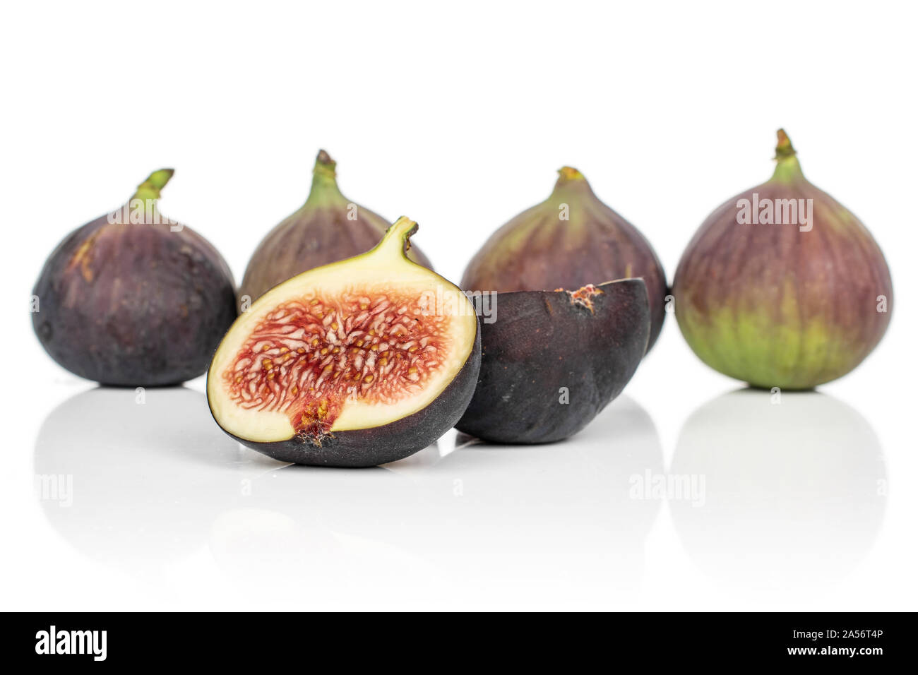 Group of four whole two halves of sweet purple fig isolated on white ...