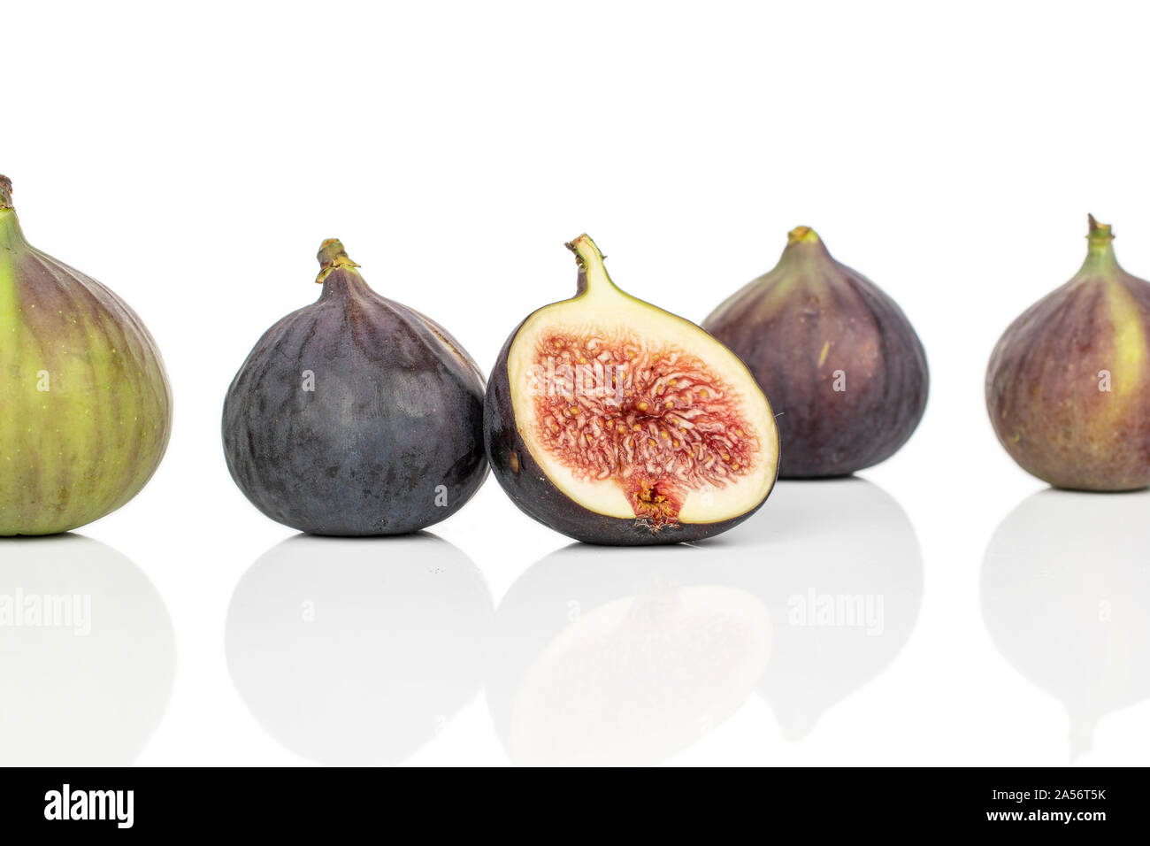 Group of four whole one half of sweet purple fig isolated on white ...