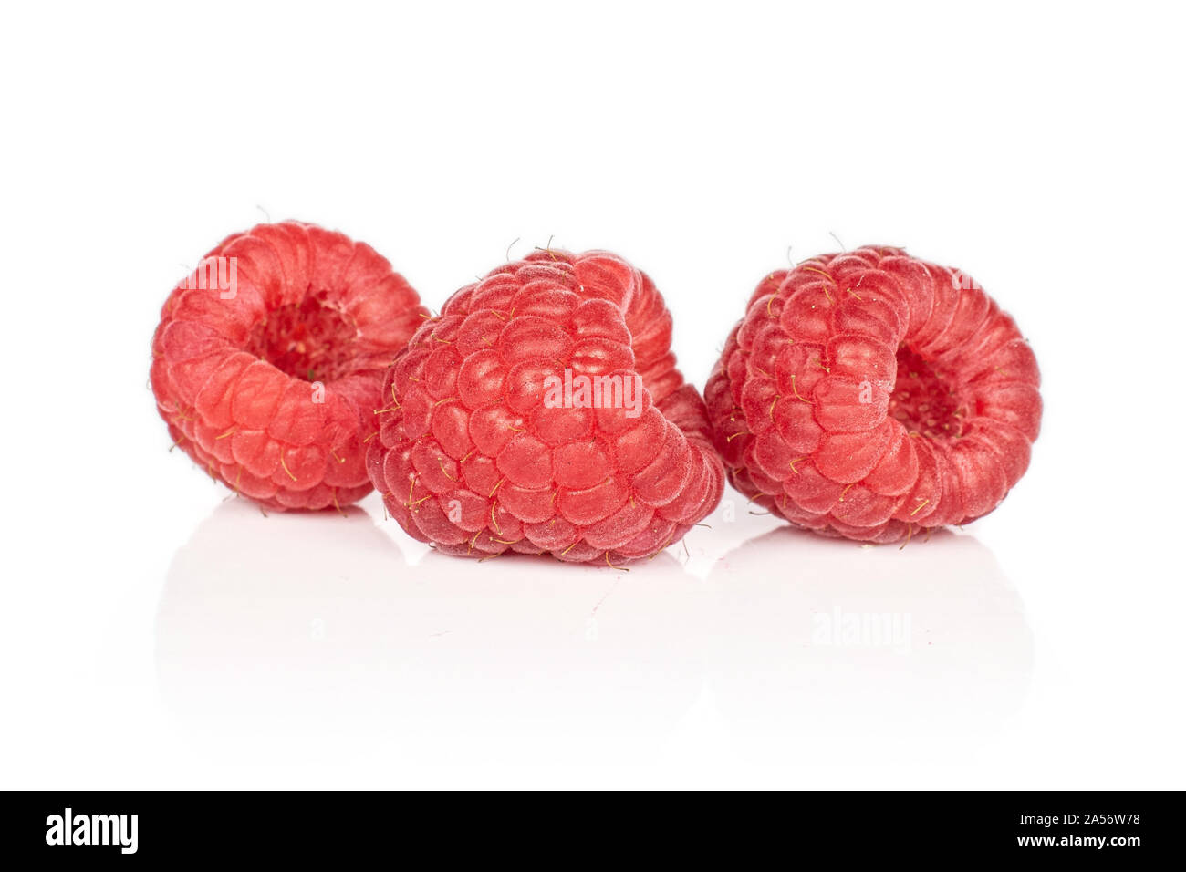 Group of three whole fresh red raspberry isolated on white background ...