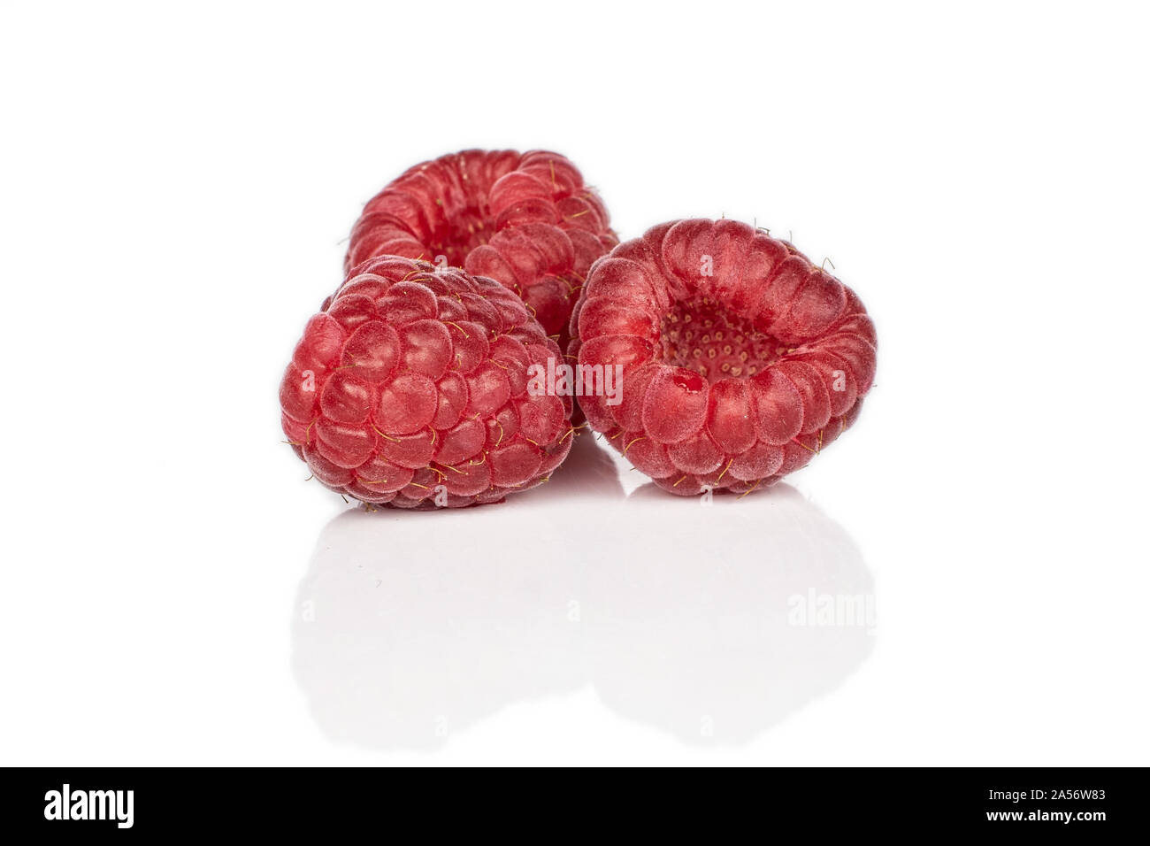 Group of three whole fresh red raspberry isolated on white background ...