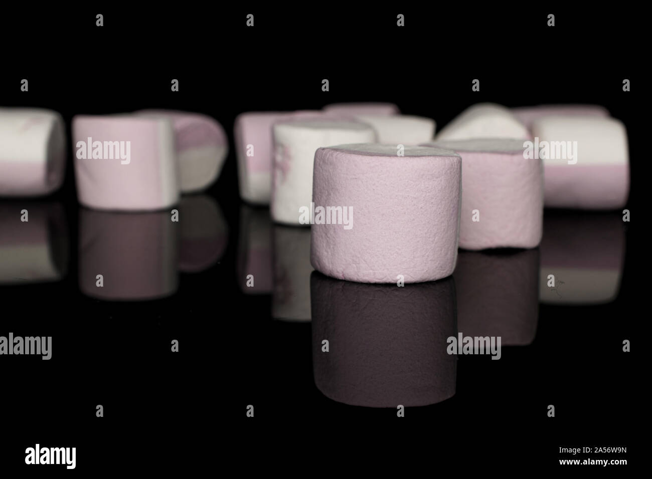 Lot of whole sweet pastel marshmallow front focus isolated on black ...
