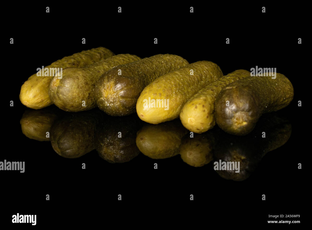 Group of six whole sour green pickle isolated on black glass Stock ...