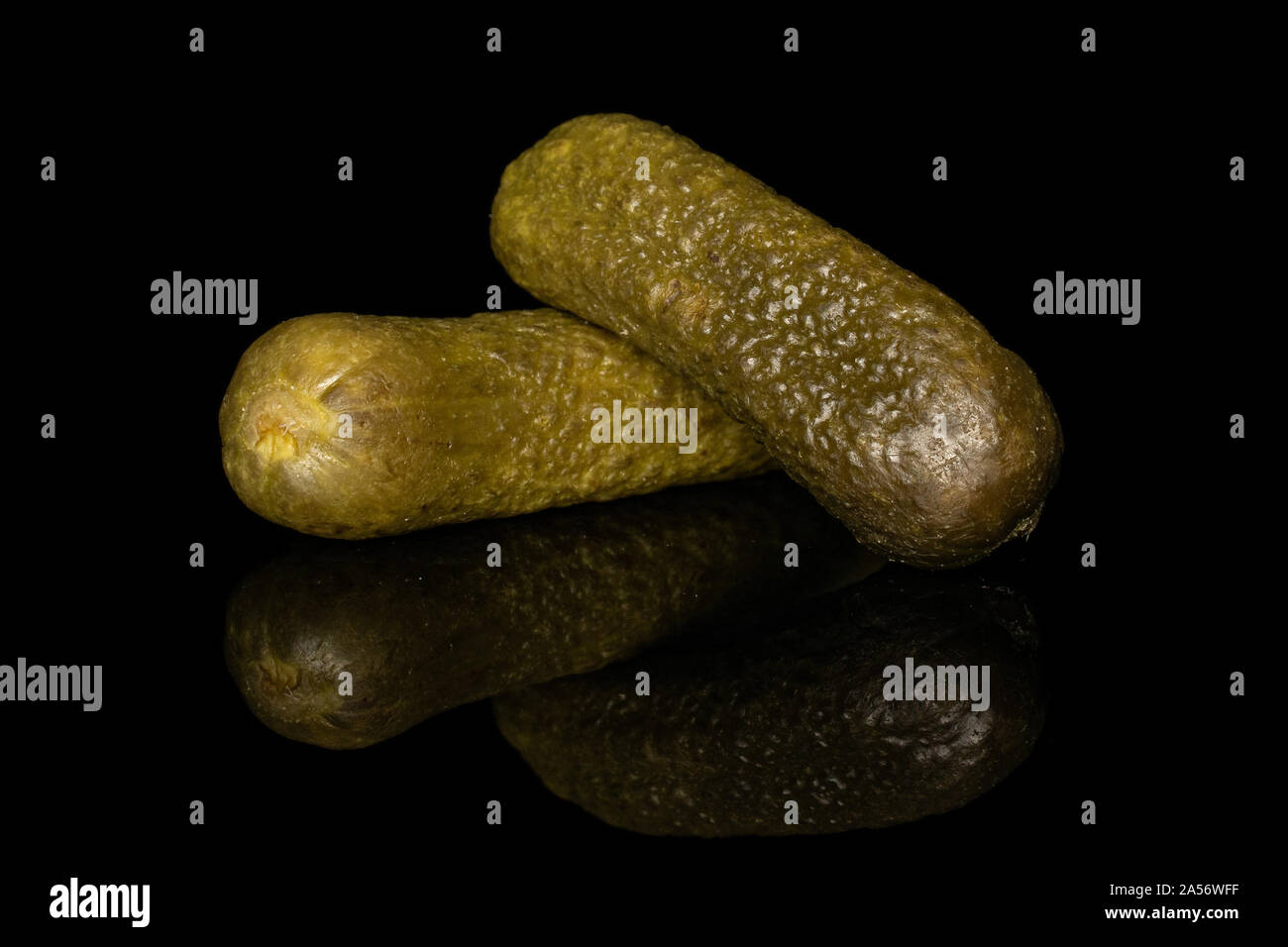 Group of two whole sour green pickle isolated on black glass Stock ...