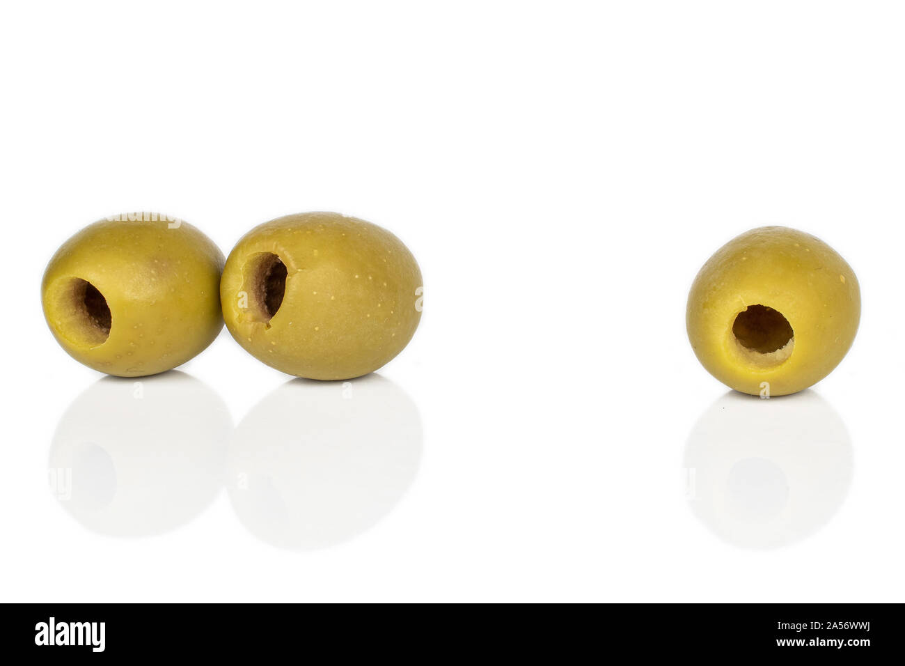 Group of three whole marinated green olive isolated on white background ...