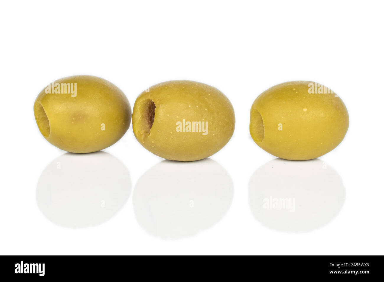 Group of three whole marinated green olive isolated on white background ...