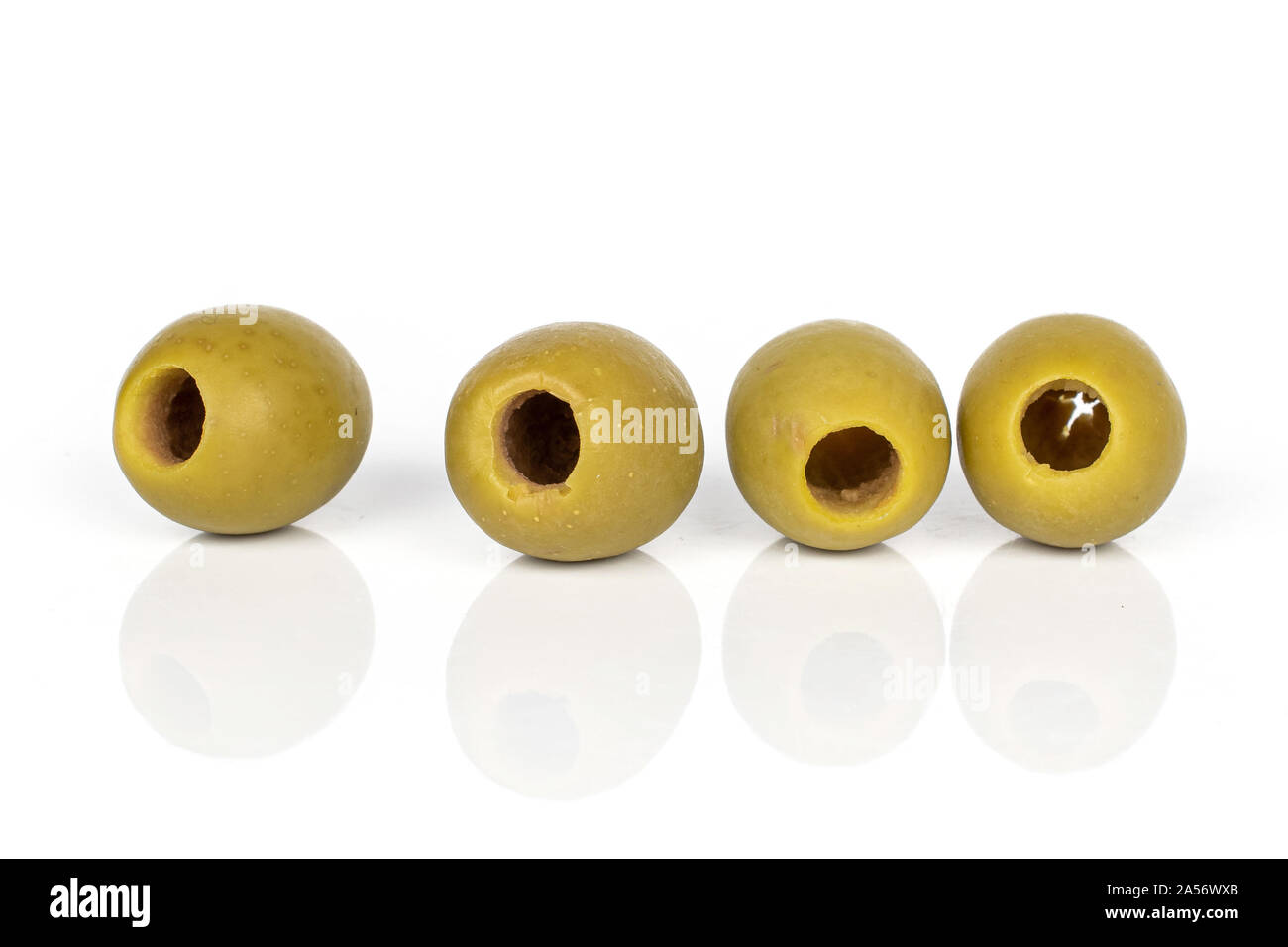 Group of four whole marinated green olive isolated on white background ...