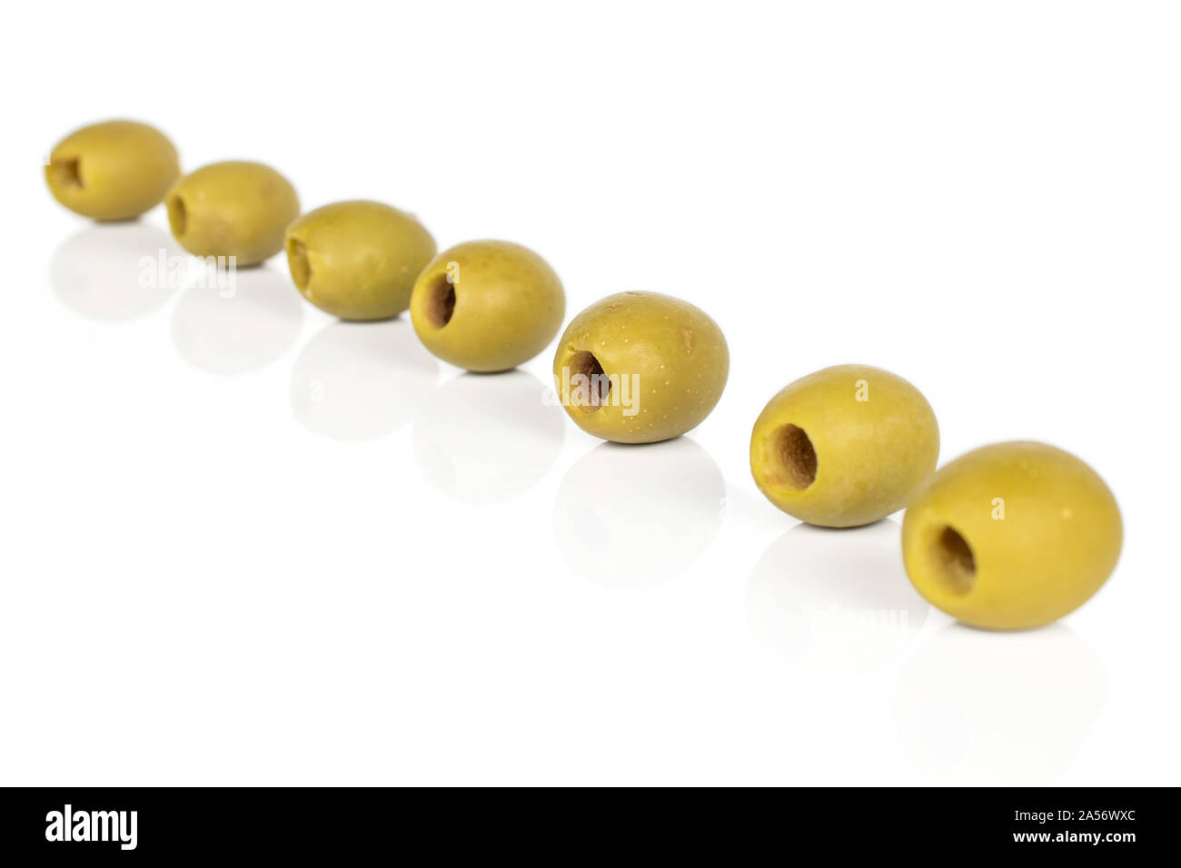 Group of seven whole marinated green olive isolated on white background ...