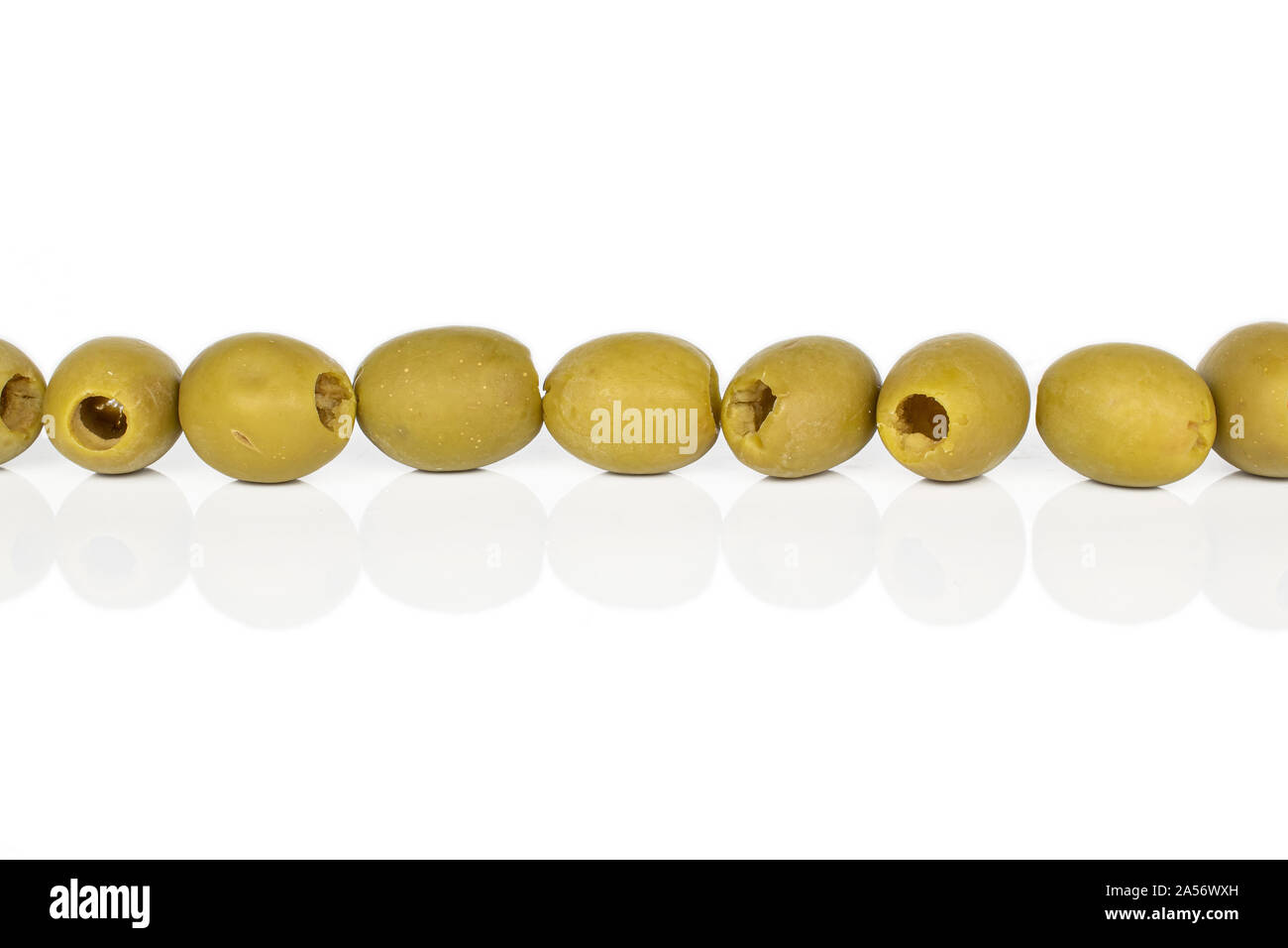 Group of nine whole marinated green olive in row isolated on white ...