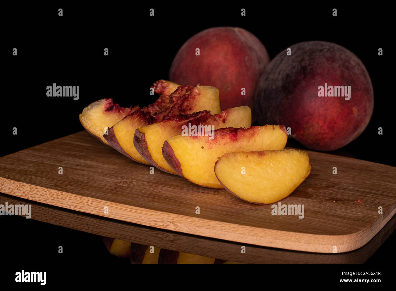 Group of two whole five slices of sweet red peach on bamboo cutting ...