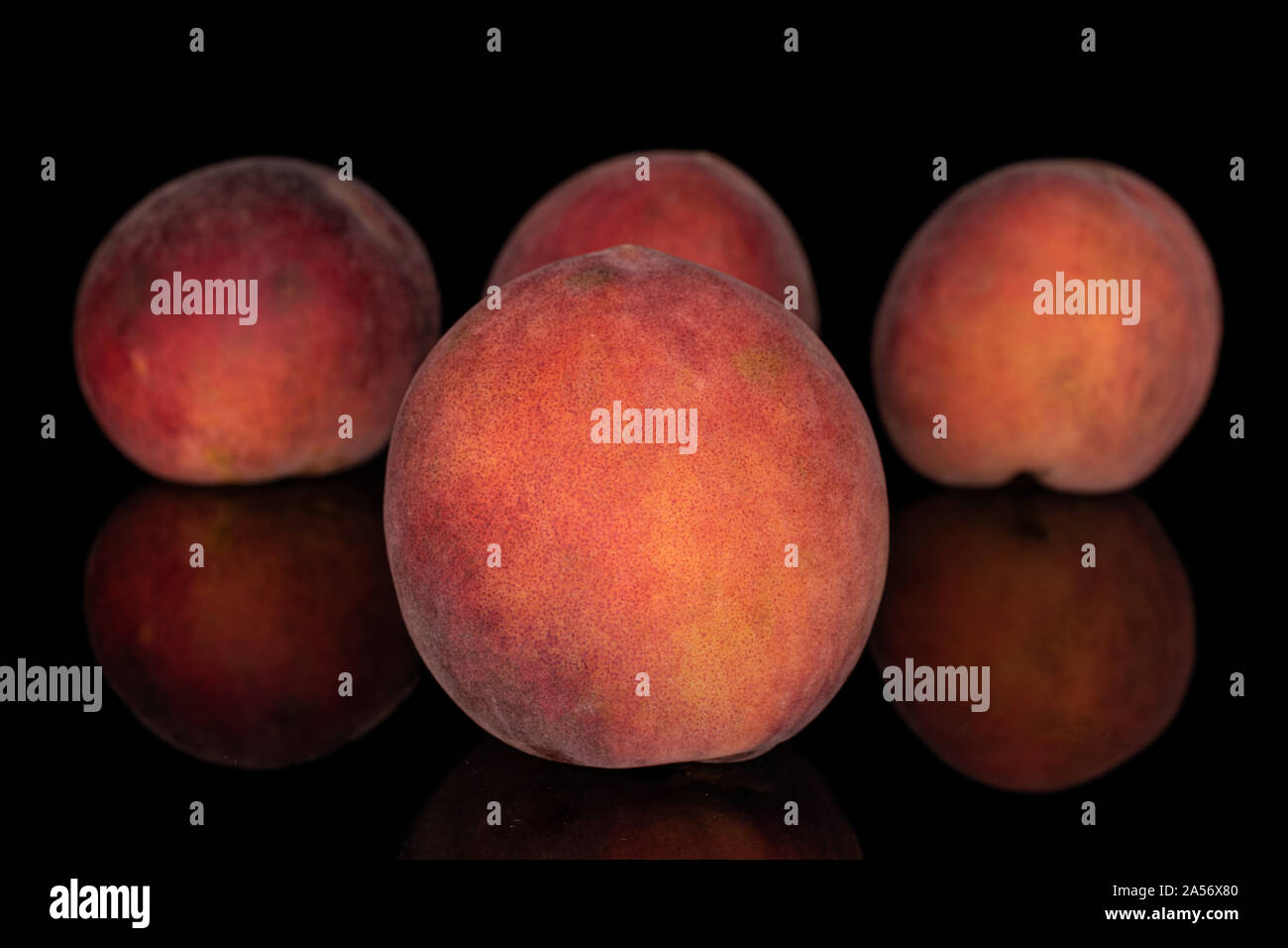 Group of four whole sweet red peach isolated on black glass Stock Photo ...