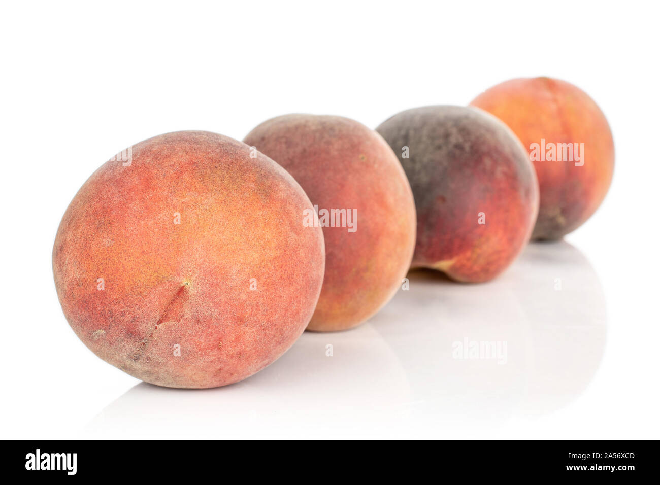 Group of four whole sweet red peach in diagonal isolated on white ...