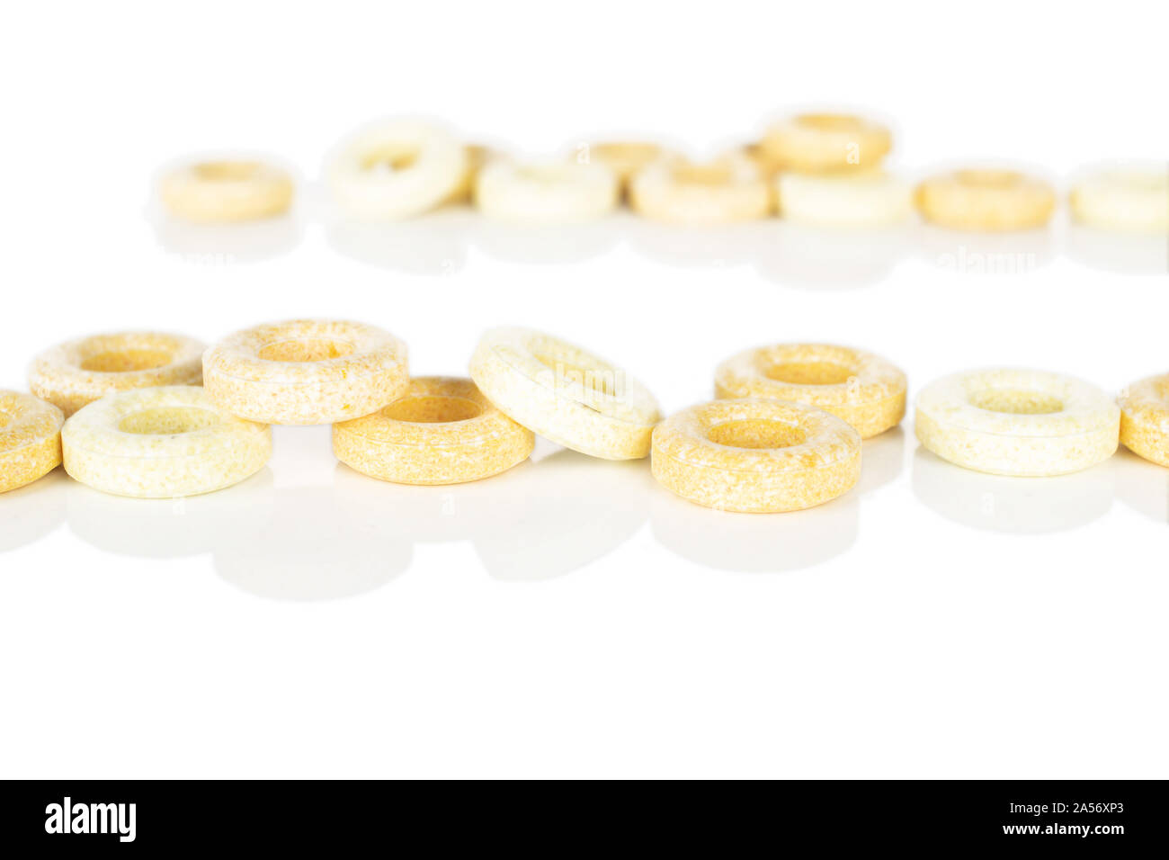 Lot of whole round pale yellow candy in row isolated on white ...